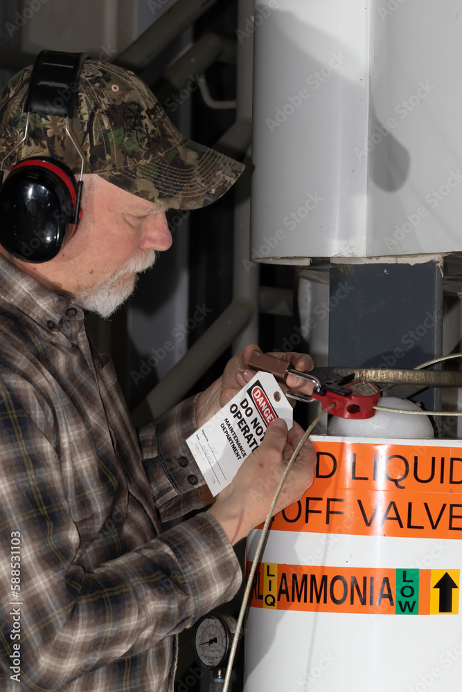 man applying LOTO on ammonia valve Stock Photo | Adobe Stock