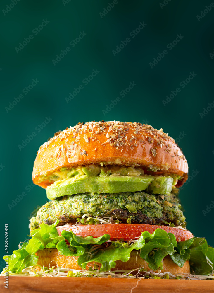 Veggie burger with green patty on brioche bun; plant based food concept ...