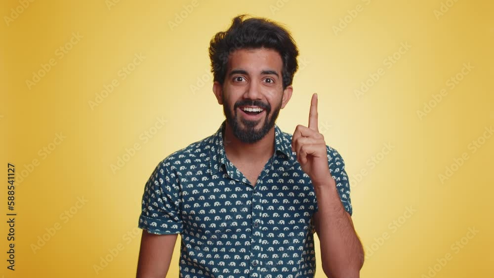 Eureka. Inspired young indian man pointing finger up with open mouth ...