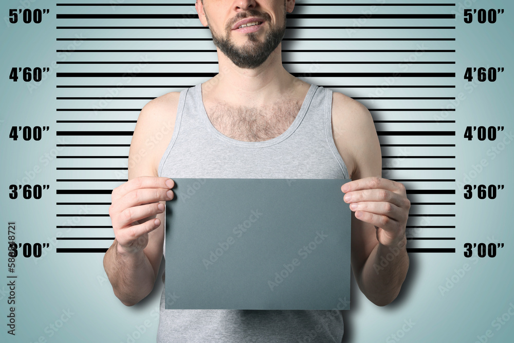 Criminal mugshot. Arrested man with blank card against height chart ...