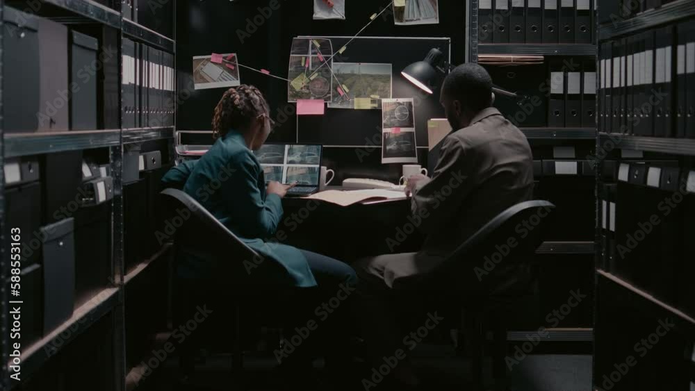 Two police officers analyzing surveillance footage, working on case ...