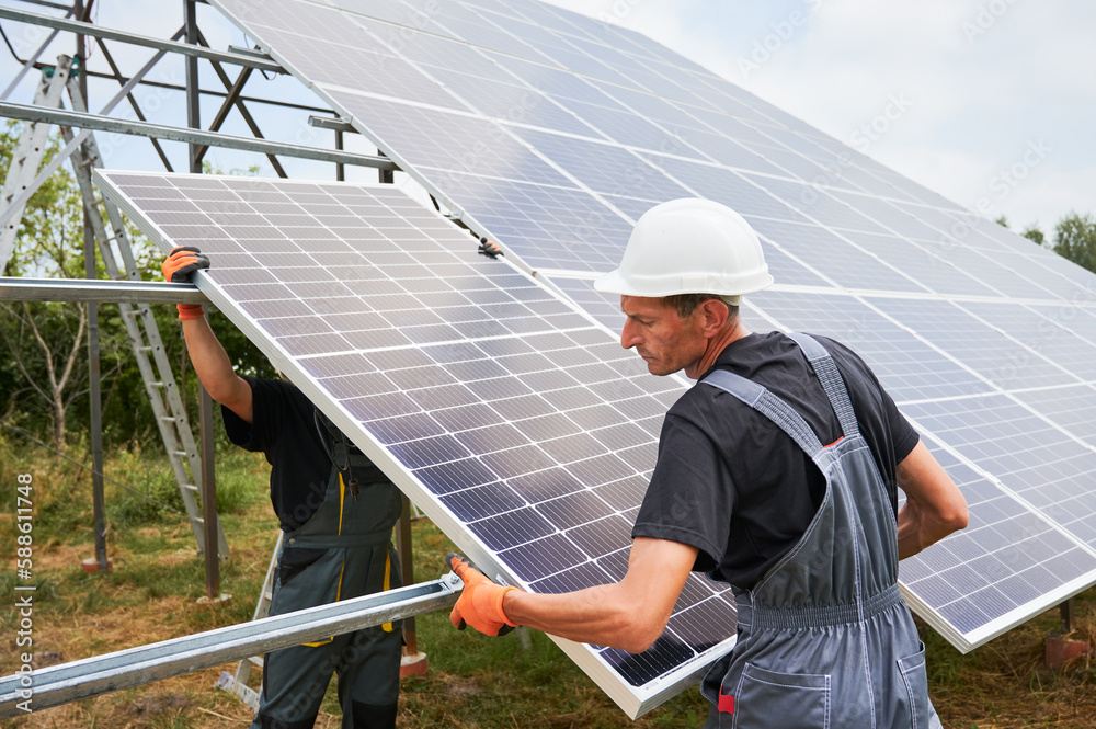 Man engineer solar installer placing solar module on metal rails with ...