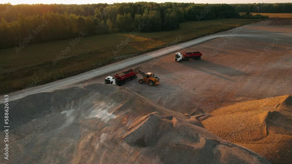 Wheel loader loading crushed stone it to the dump truck. Mining work in ...