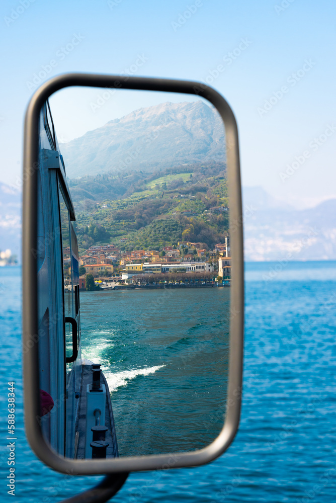 Rear view mirror of a ferry on the blue waters of Lake Iseo, Italy ...