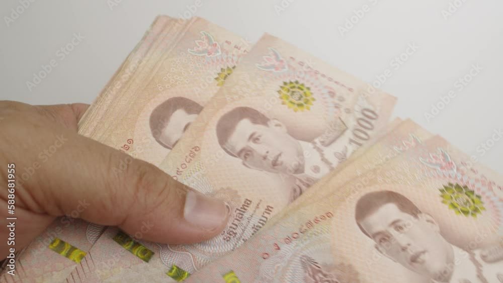 Select focus of hands counting a lot of thousands Thai baht banknotes ...