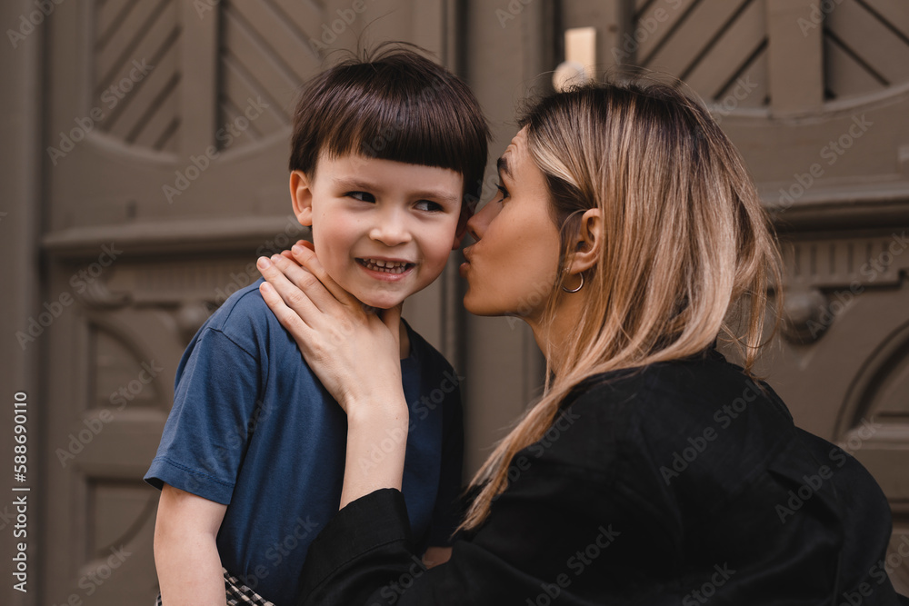 Happy mom tell secret or joke on ear her son. They look happy and ...