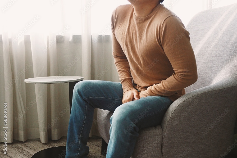 Man using his hands touching and covering his crotch suffering from his ...