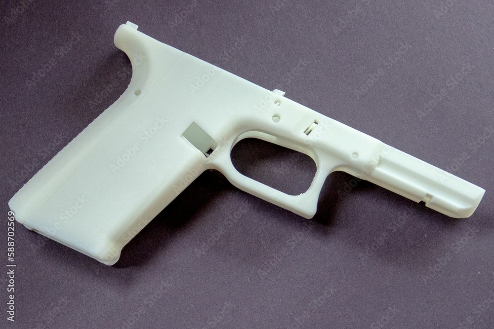 Closeup of 3D printed white "Ghost Gun" on a dark background. Stock ...