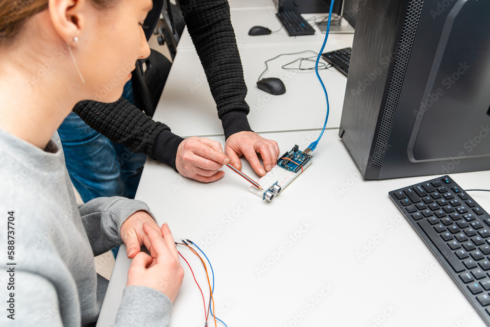Foto de Teacher helping his teen student with diy robot on stem ...