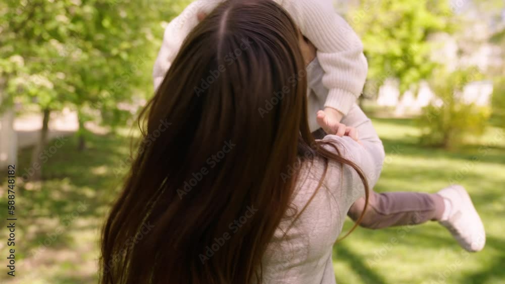 happy family. mom hugs child girl daughter park. cheerful girl spinning ...