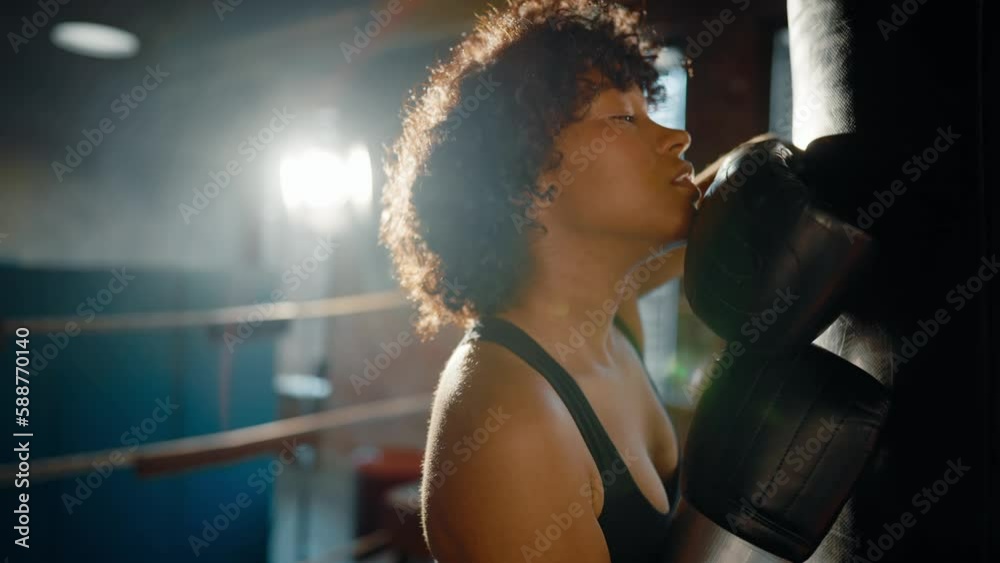 African american woman boxer stands near punching bag on boxing ring ...