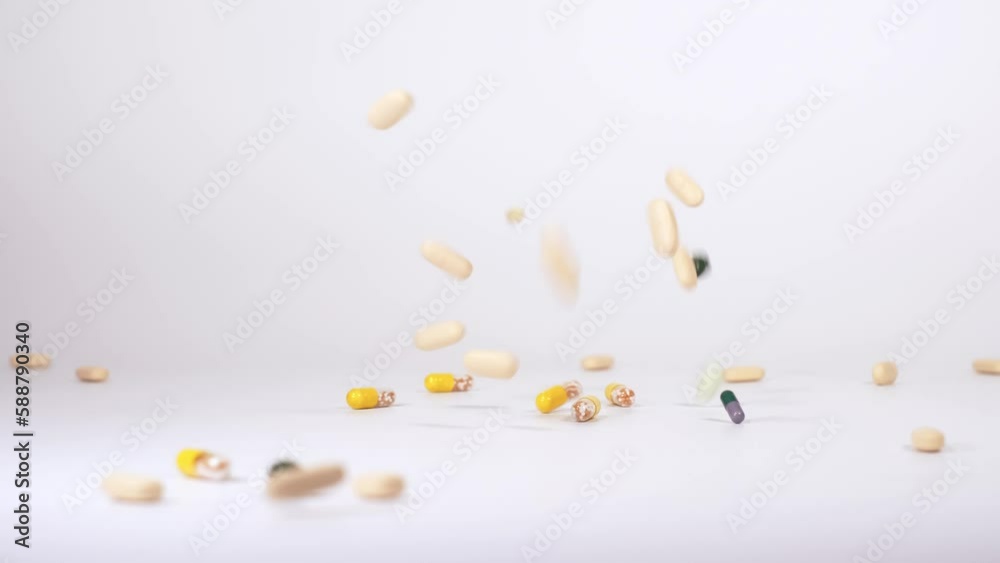 Colourful pharmaceutical products, tablets, pills and capsules falling ...