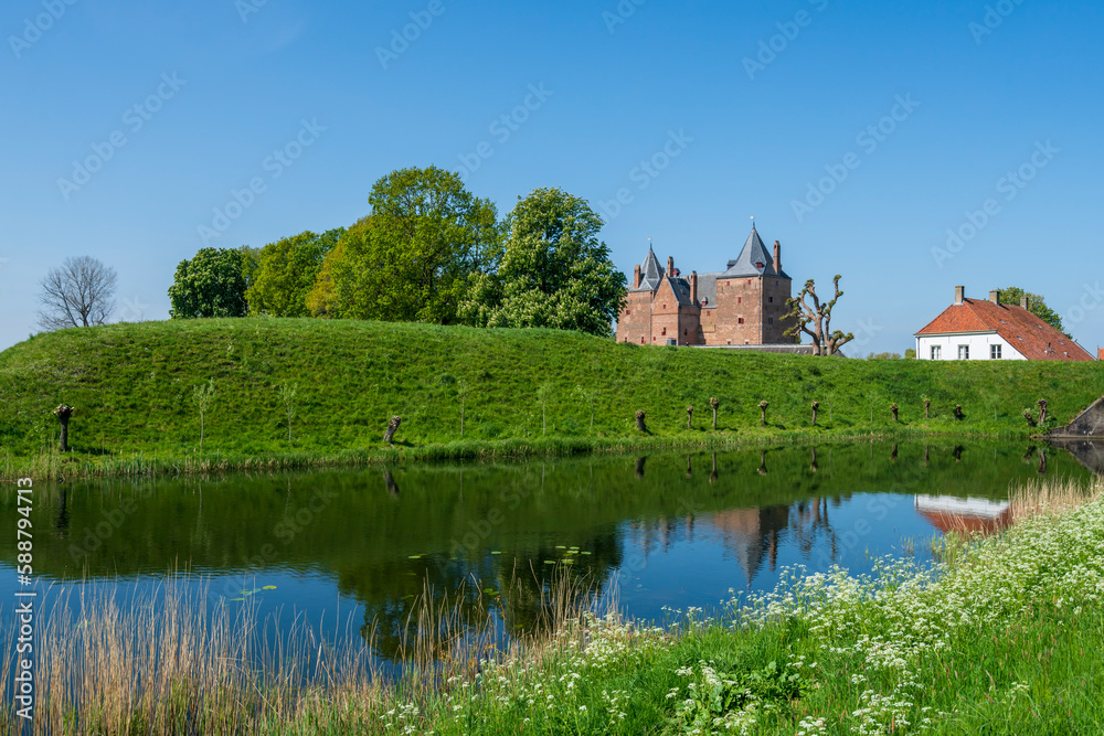 Captivating view across the moat water over the dike to Slot Loevestein ...
