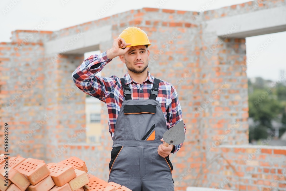 construction mason worker bricklayer installing red brick with trowel ...
