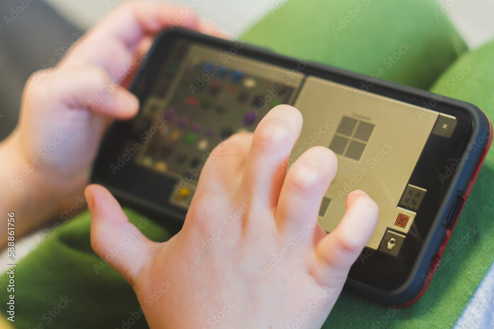 Phone in hands of child. Little boy playing mobile games on smartphone ...