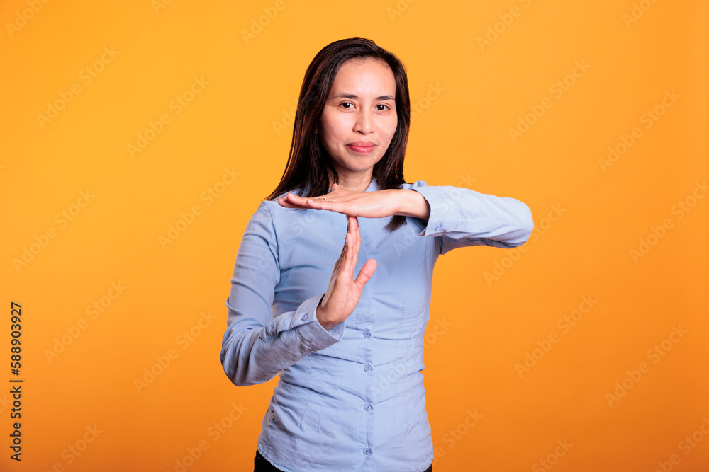 Filipino woman showing timeout and break gesture in studio, doing t ...
