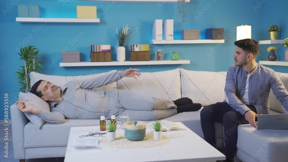 Son helping his sick father get up. The father is sick and wants to get ...