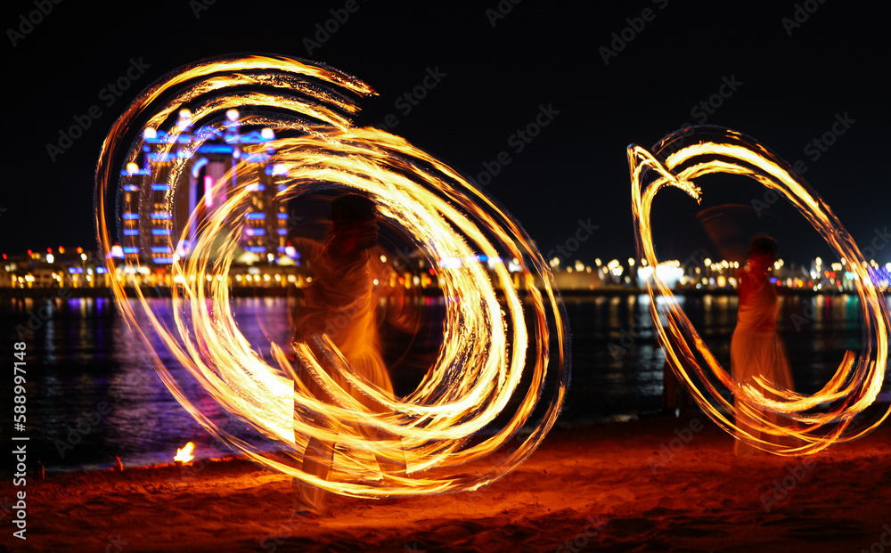 Fire dancers, swing fire dancing show. Create shapes from fire on a ...