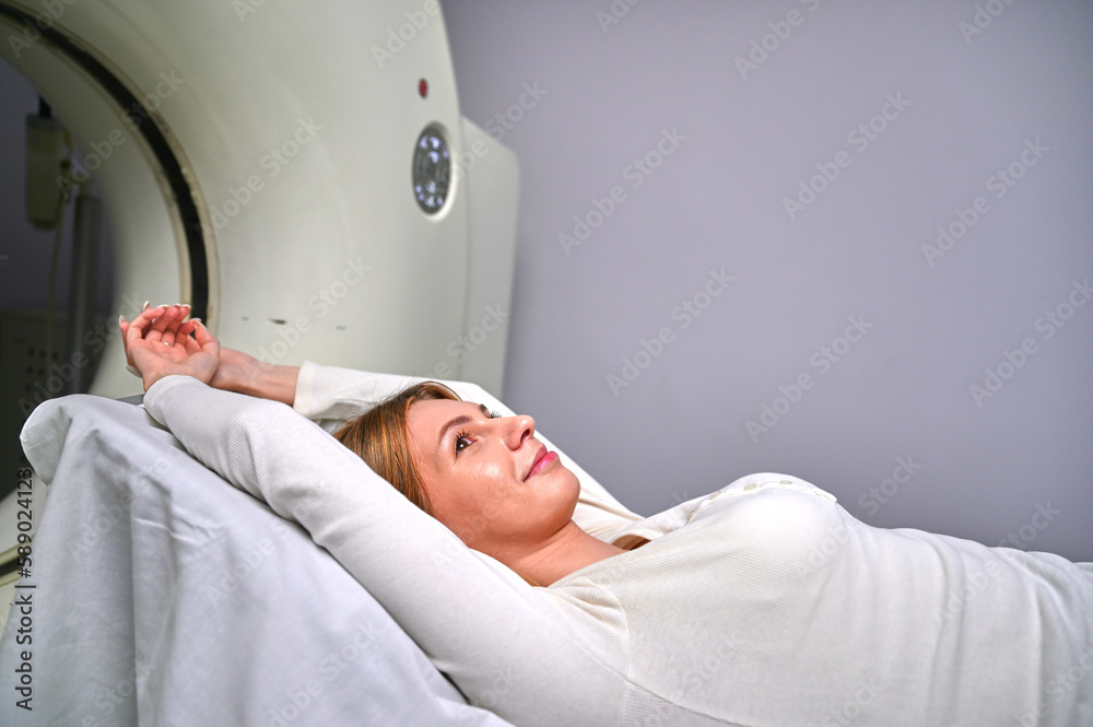 A young pretty girl is undergoing a CT scan in a medical clinic ...