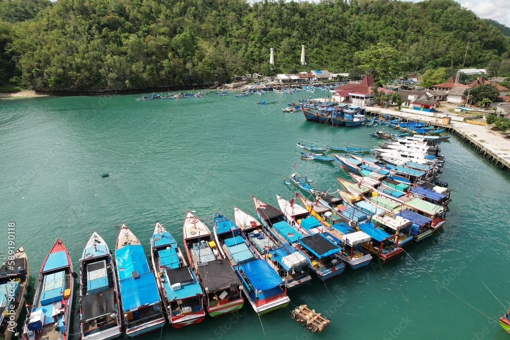 blue and white fishing boat anchored in a harbor. aerial photography of ...