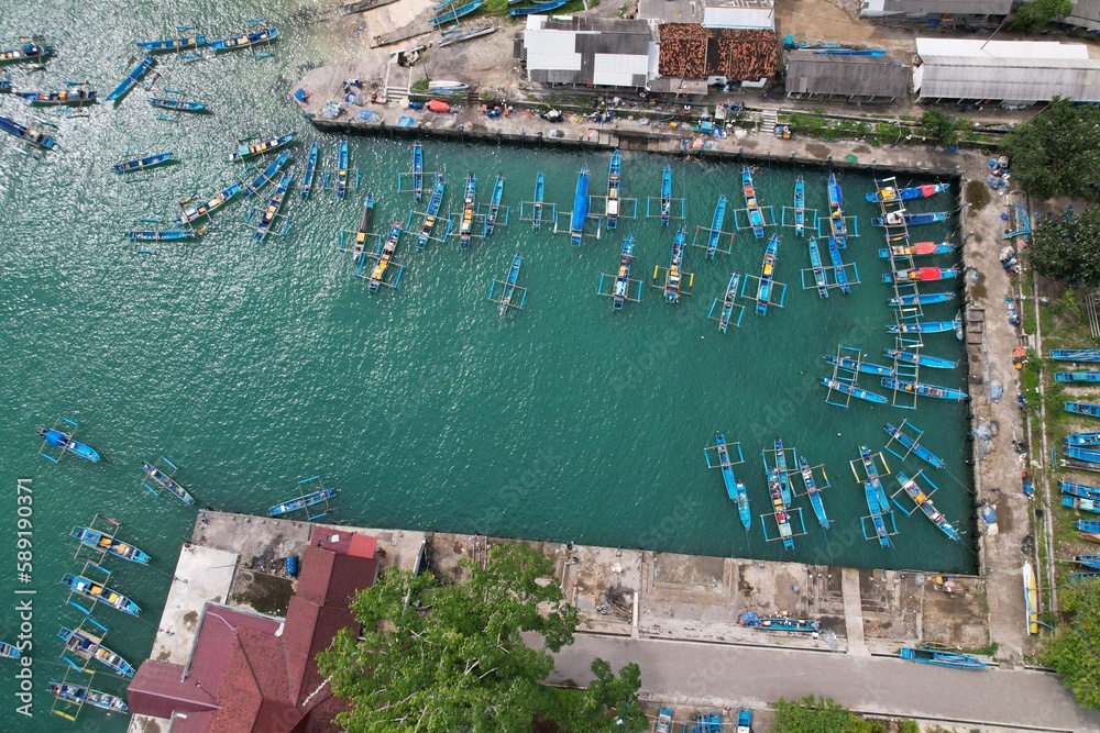 blue and white fishing boat anchored in a harbor. aerial photography of ...