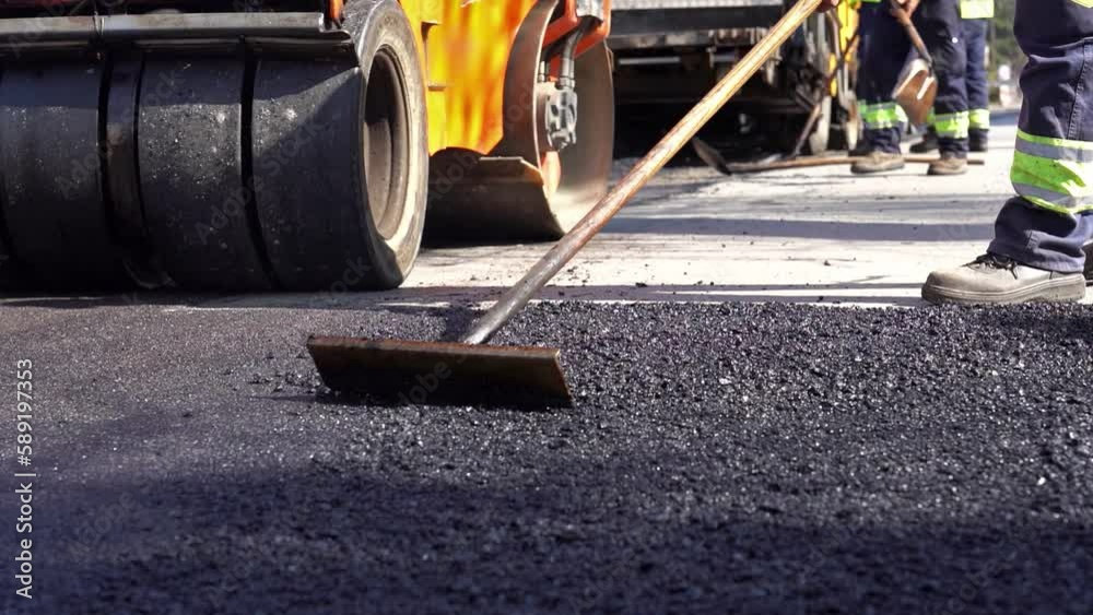 Worker Leveling Fresh Asphalt on a Road Construction Site - Slow Motion ...
