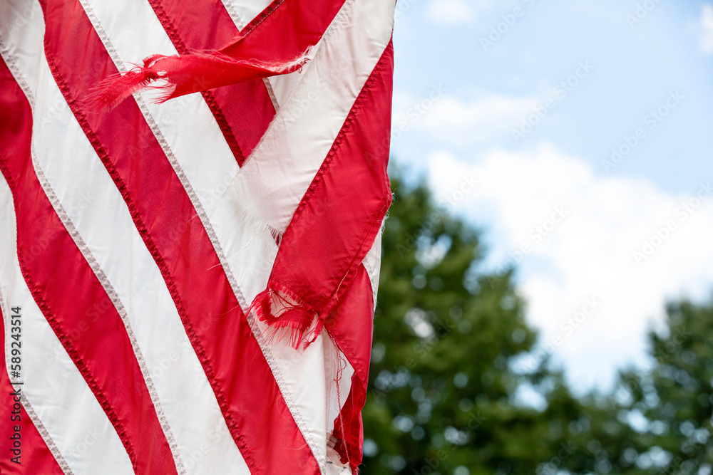 Old, tattered and torn American Flag flying outdoors. Patriotic and ...