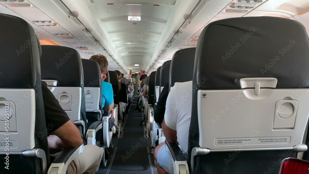Back of airplane interior. passenger perspective in plane corridor ...