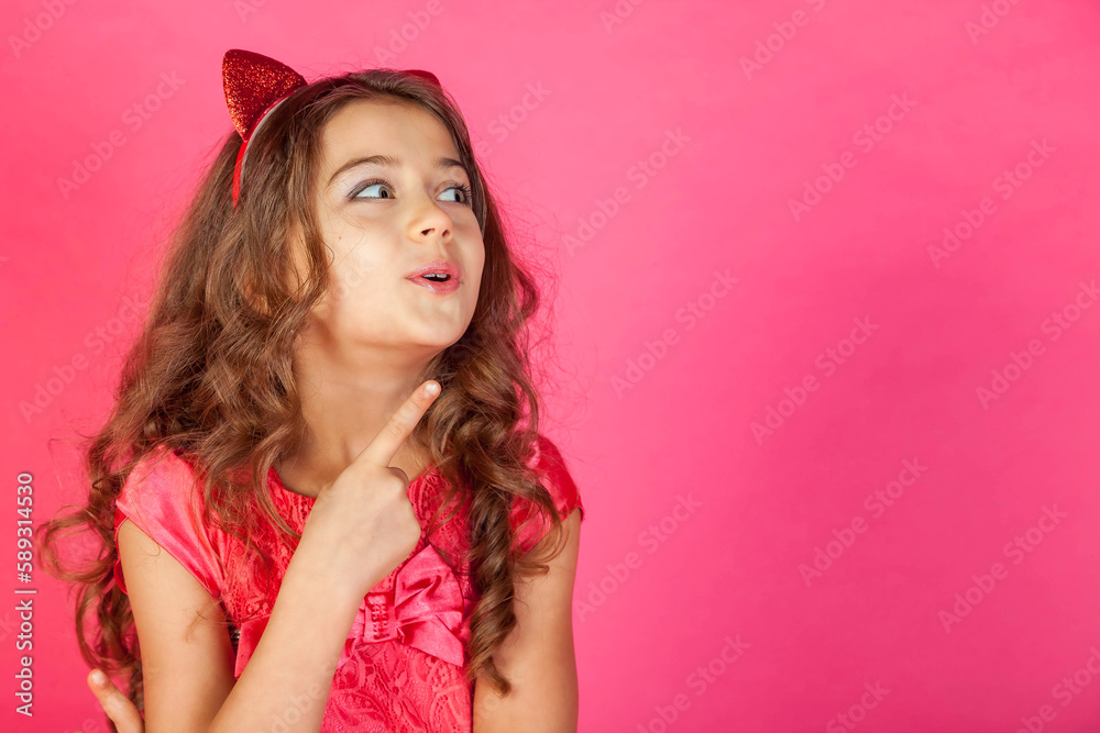 Happy smiling little girl in pink dress pointing index finger up at ...