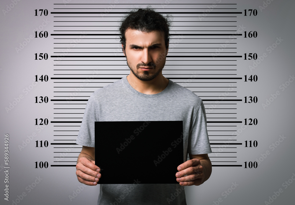 Criminal mugshot. Arrested man with blank card against height chart ...