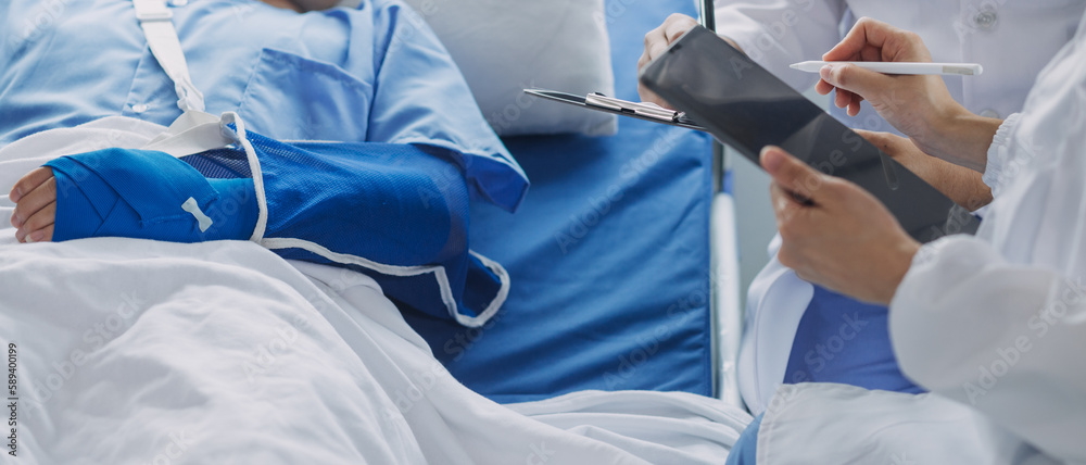 Injured patient showing doctor broken wrist and arm with bandage in ...