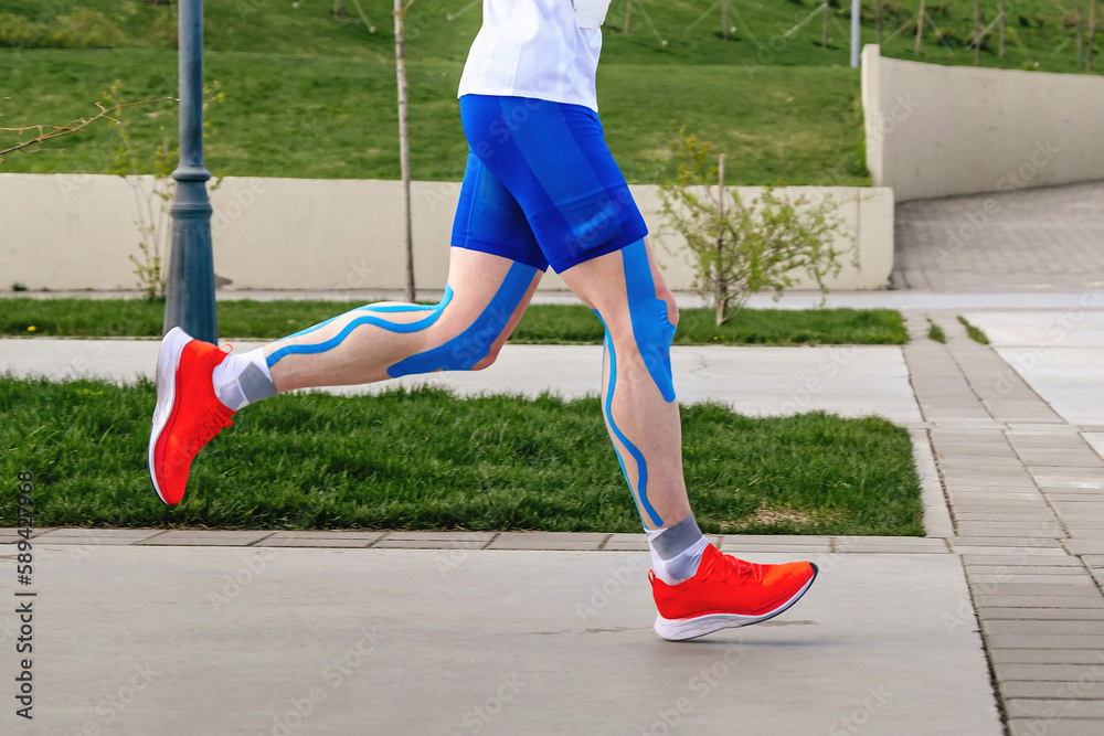 legs runner athlete in blue kinesiotaping on thigh, calf muscles and ...