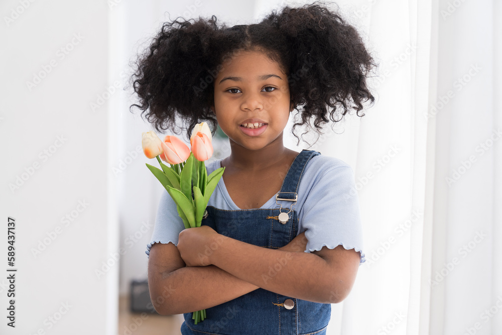 African American child girl standing holding tulips flower with happy ...