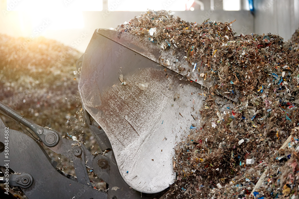 Huge bucket of heavy loader processing pile of refuse-derived fuel (RDF ...