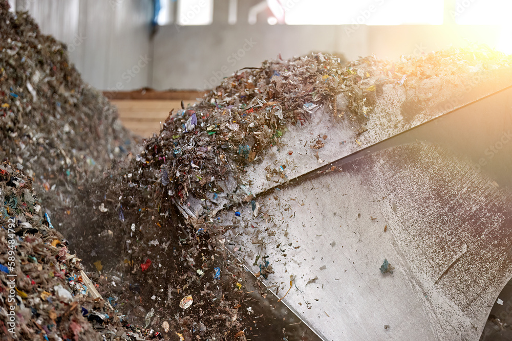 Huge bucket of heavy loader processing pile of refuse-derived fuel (RDF ...
