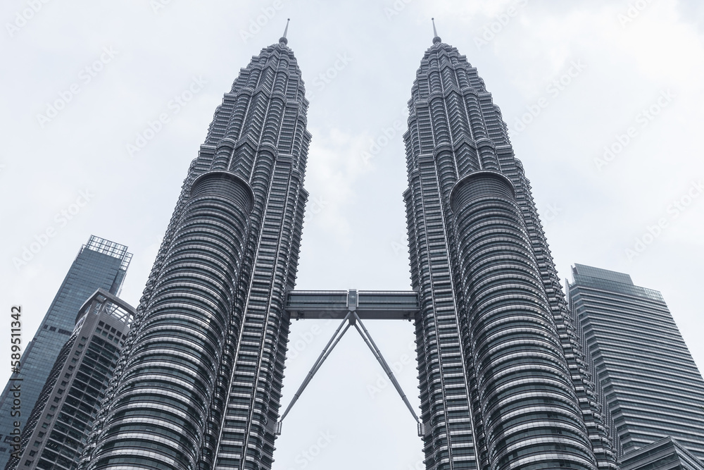 Petronas Twin Towers building is under bright cloudy sky on a daytime ...