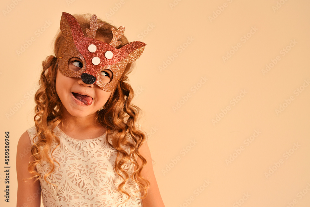 Little cute girl in a carnival masquerade deer mask made of shiny ...