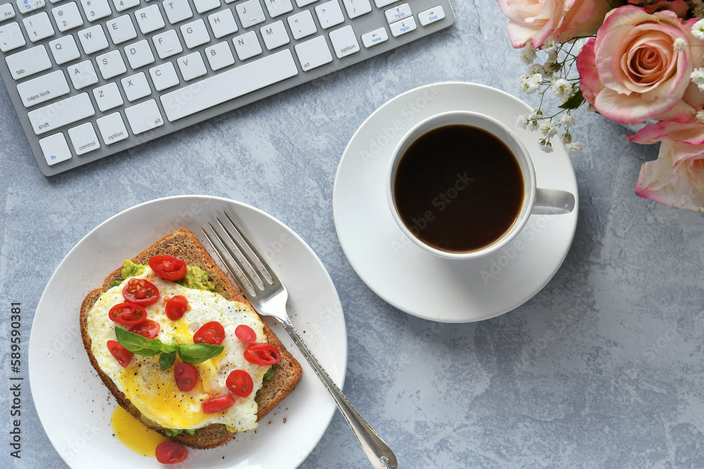 Avocado toast with fried egg on desk with computer keyboard & coffee ...