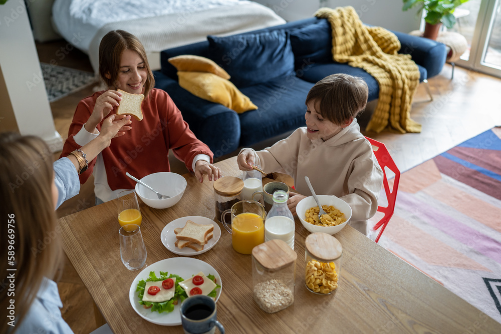 Happy smiling children brother and sister sitting at kitchen table with ...