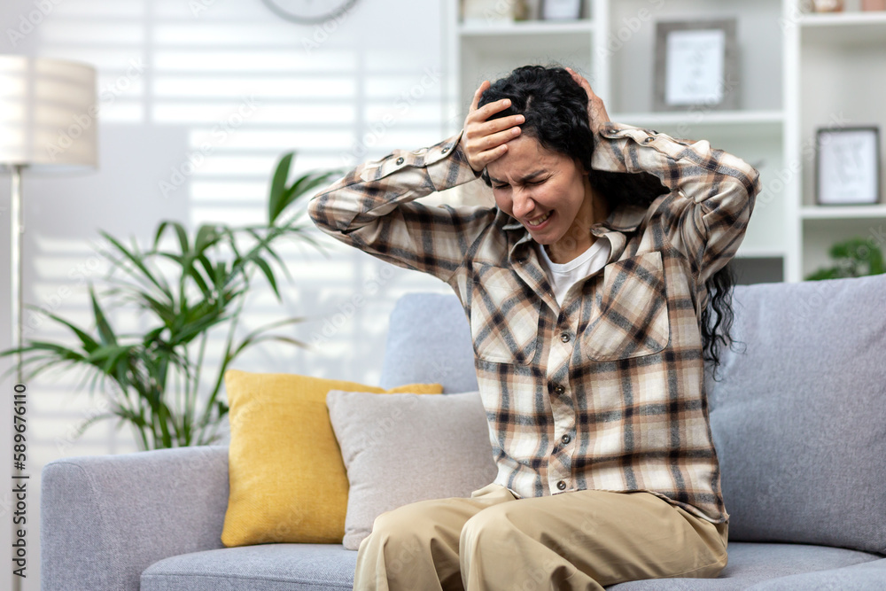 Headache and migraine in woman alone at home, Hispanic woman sick has ...