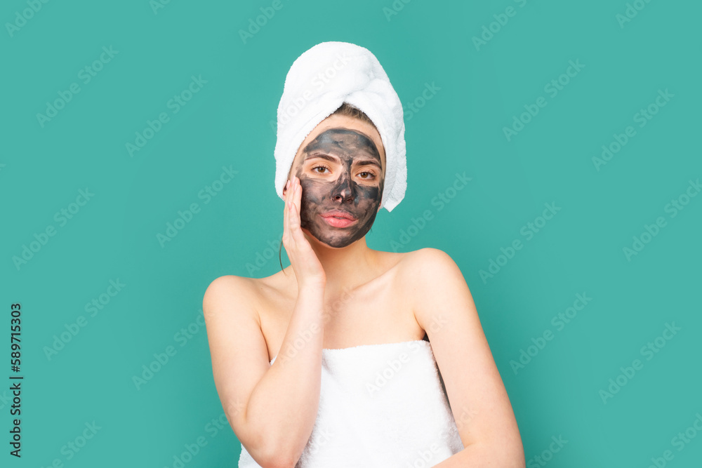 Fotografia do Stock: Facial mask. Skin care. Woman applying black clay ...