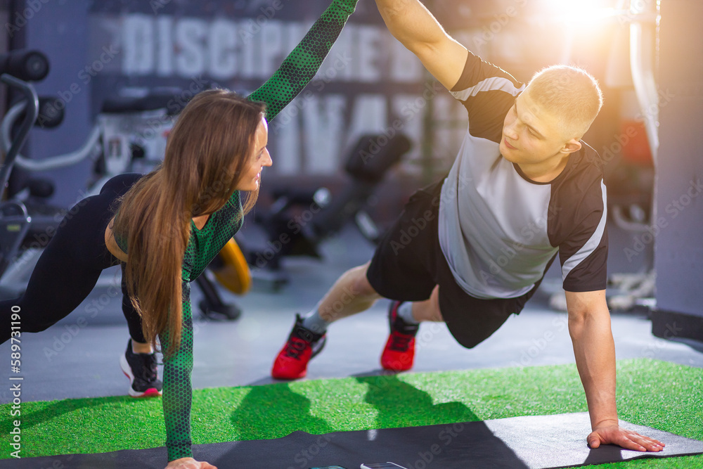 Foto de Young women and man go in for sports at gym. Two athletes are ...
