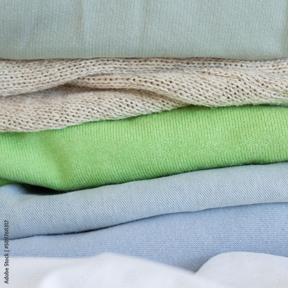 Pile of clothes, pastel color palette of stacked sweaters and jeans ...