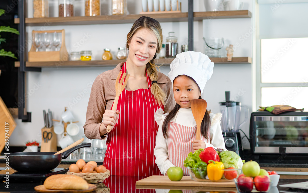 Asian young little cute girl chef daughter wears white tall cook hat ...