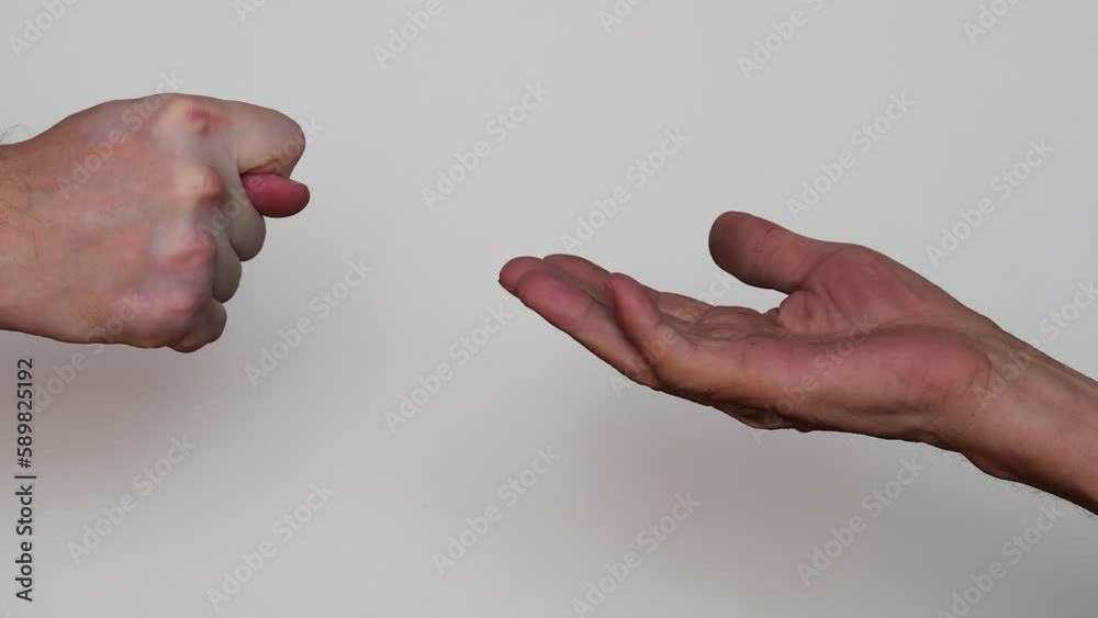 the hand of a man shows figs to the palms of an old man begging for ...
