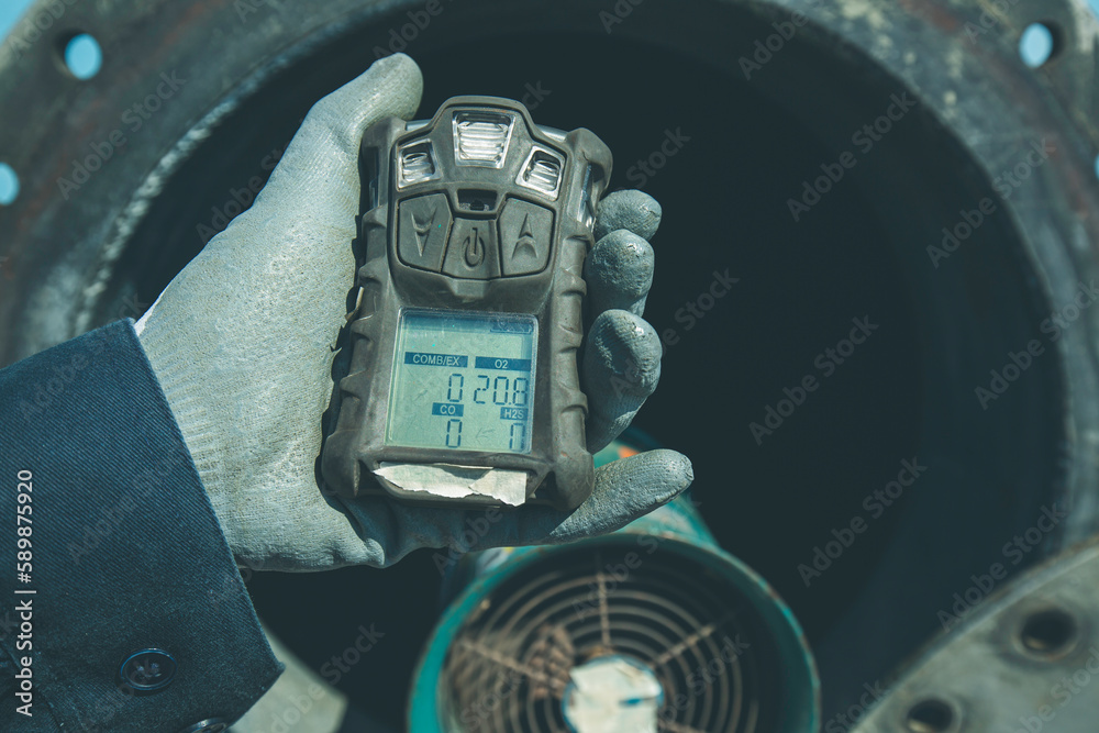 Worker hand holding gas detector inspection safety gas testing at front ...
