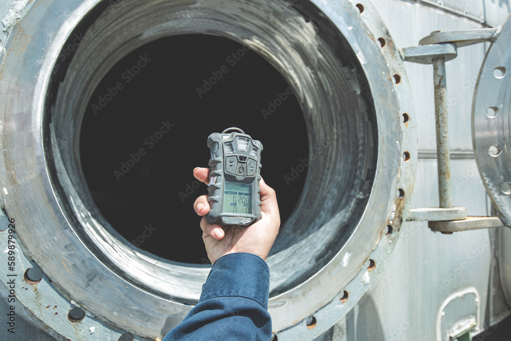 Worker hand holding gas detector inspection safety gas testing at front ...