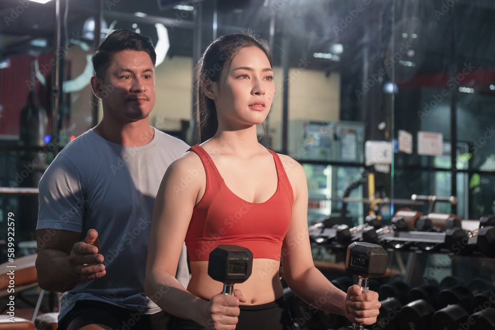 Young sportswoman and trainer in gym, Personal instructor help young ...