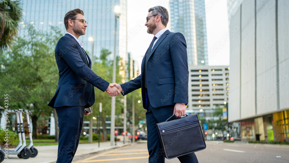 Business man shaking hands. Two businessmen handshake outdoor ...