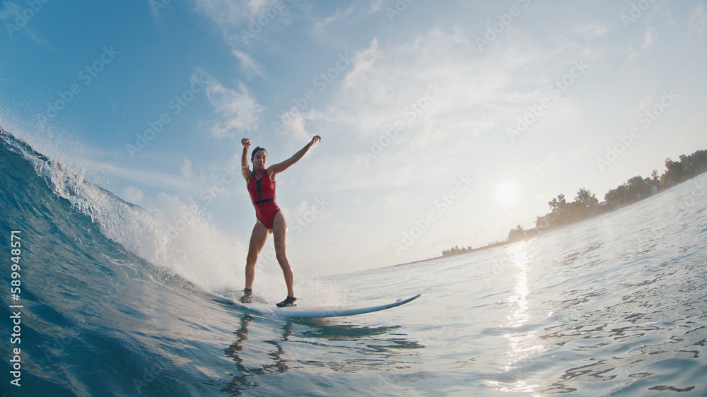 Girl surfer rides the wave. Woman in red suit surfs the ocean wave in ...